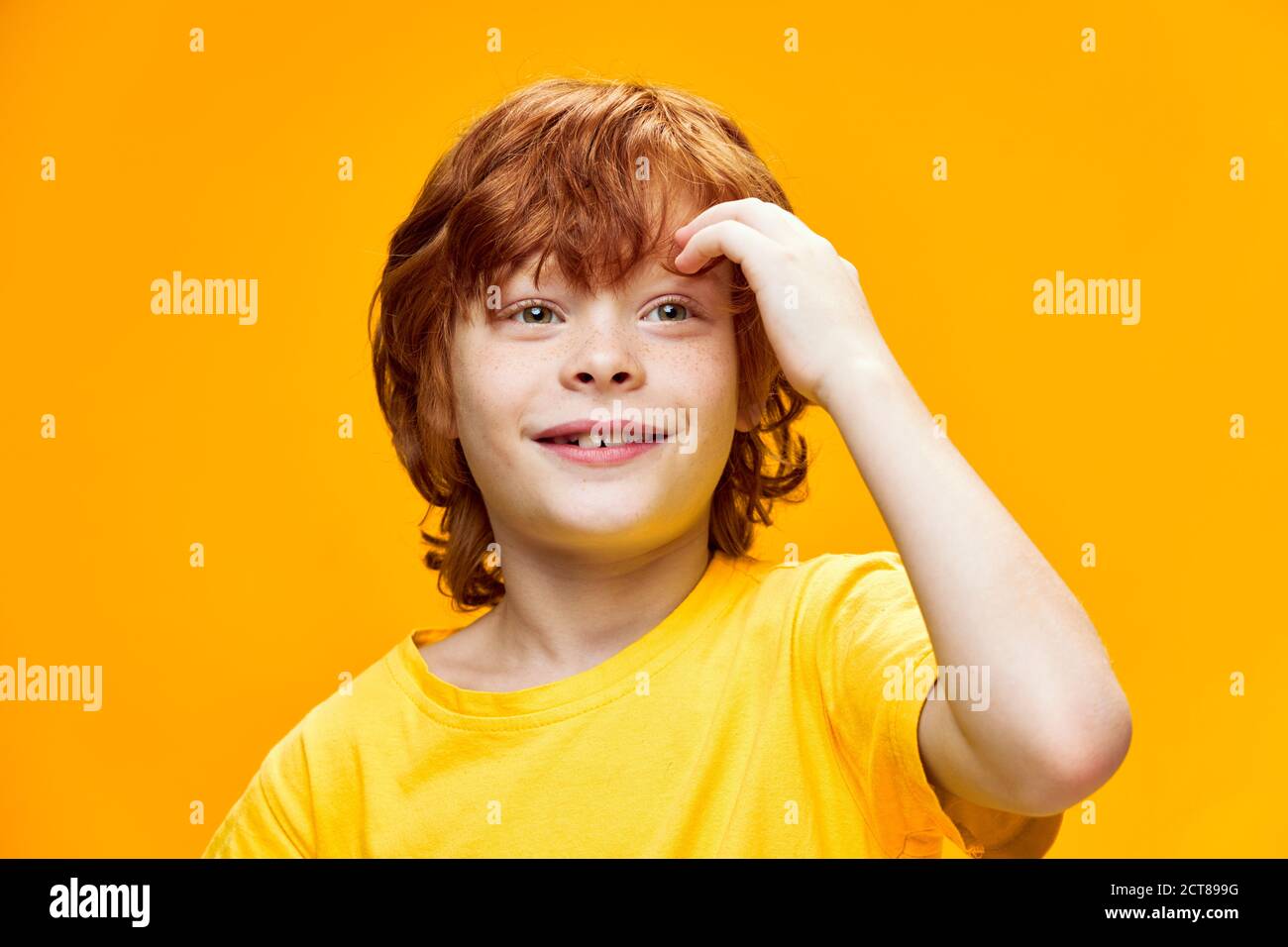 A dreamy red-haired boy touches his face with his hand Stock Photo - Alamy