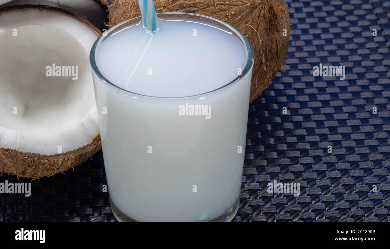 Coconut and glass with coconut water. Coconut water is a sweet-tasting ...