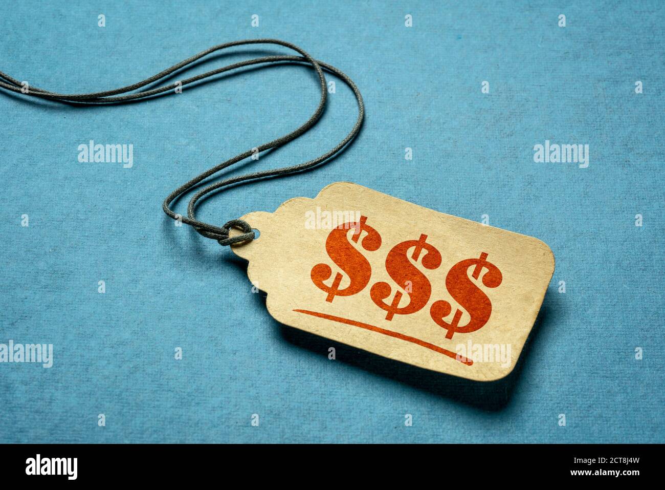 triple dollar sign - red stencil text on a paper price tag against blue ...