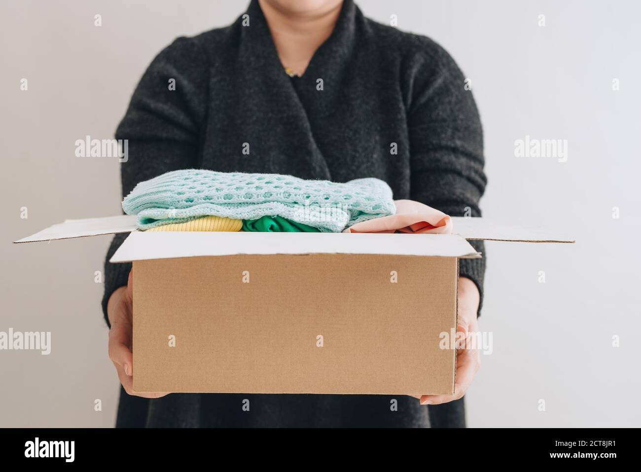 Woman holding box of clothes hi-res stock photography and images - Alamy