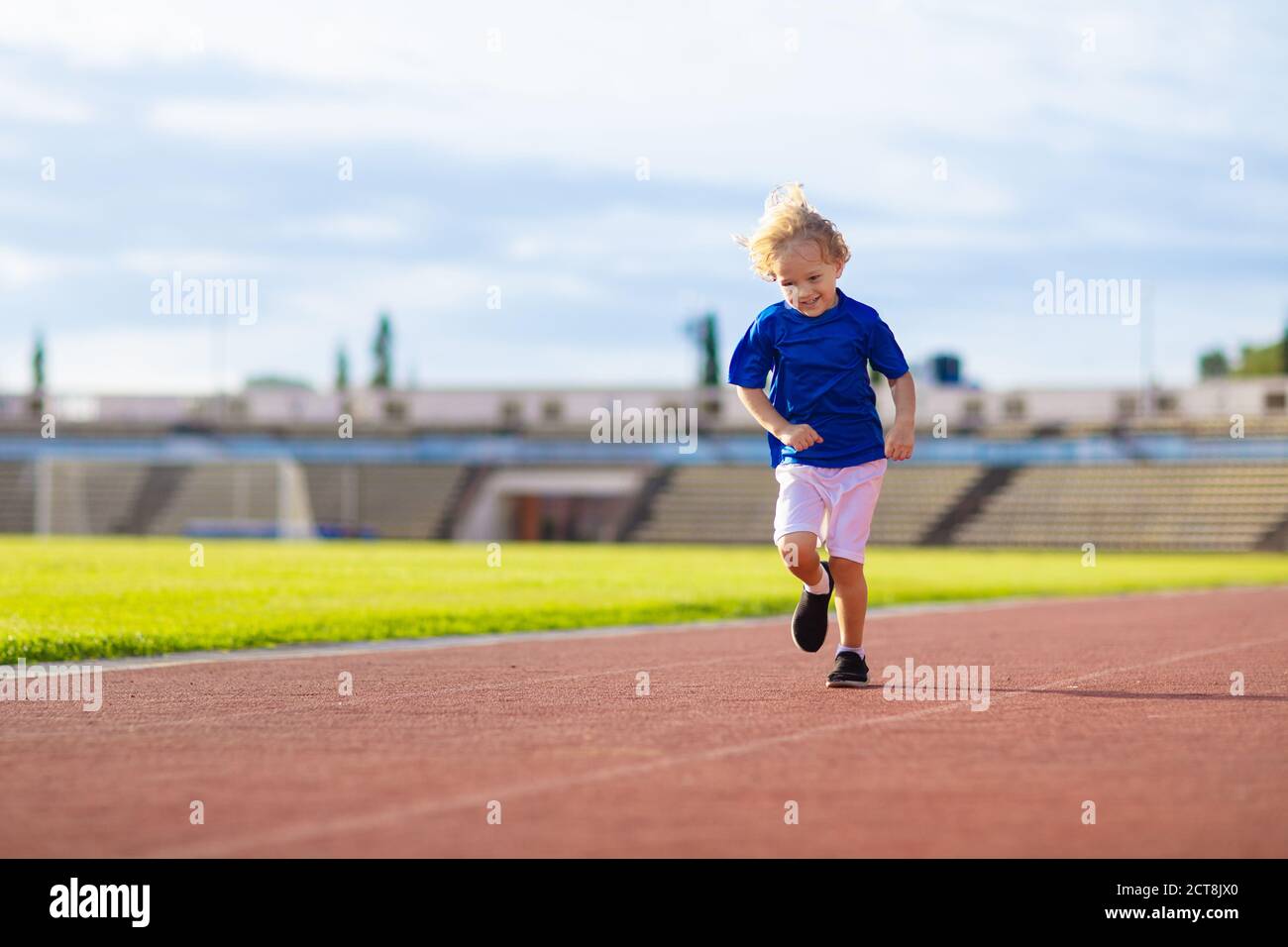 Child running in stadium. Kids run on outdoor track. Healthy sport ...