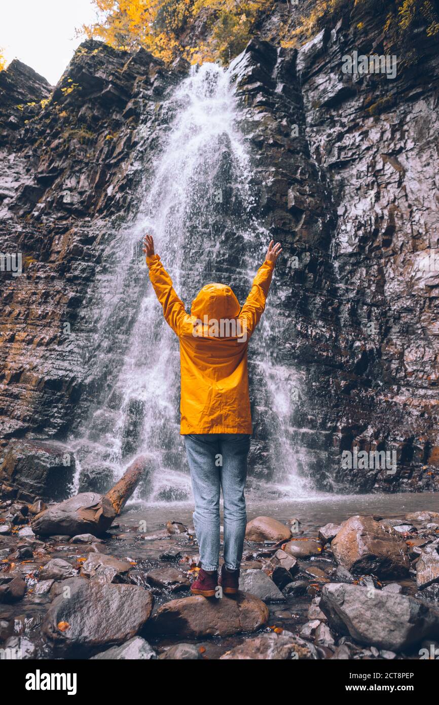 woman in yellow raincoat at autumn waterfall Stock Photo - Alamy