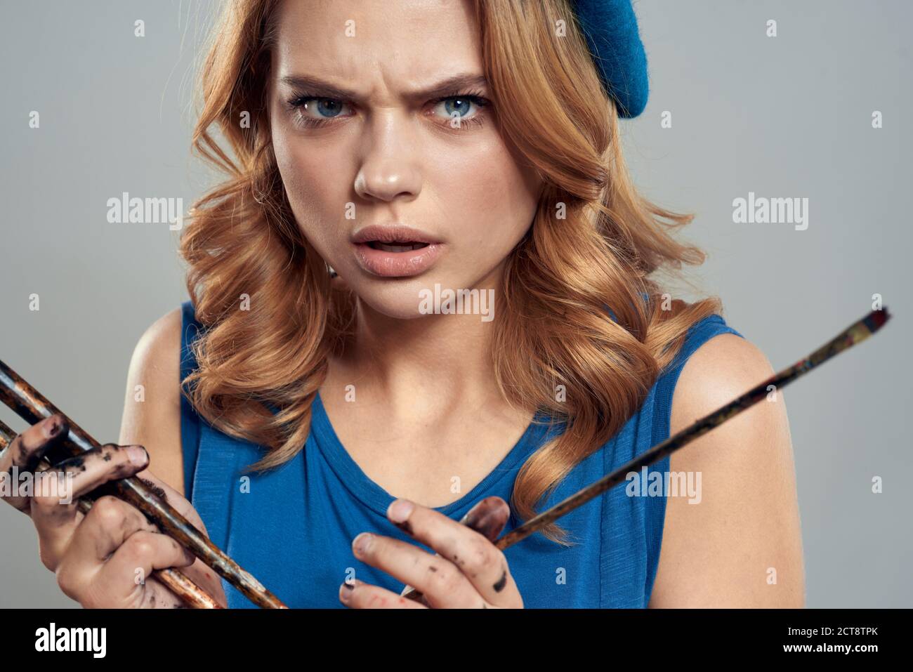 Pretty woman artist paintbrush near face blue beret close-up art Stock ...