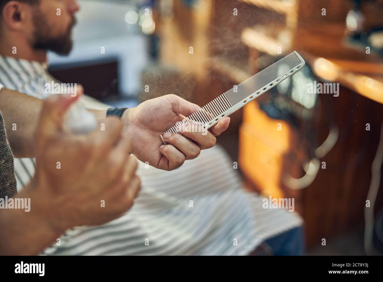 Hair comb in hands of a professional barber Stock Photo - Alamy