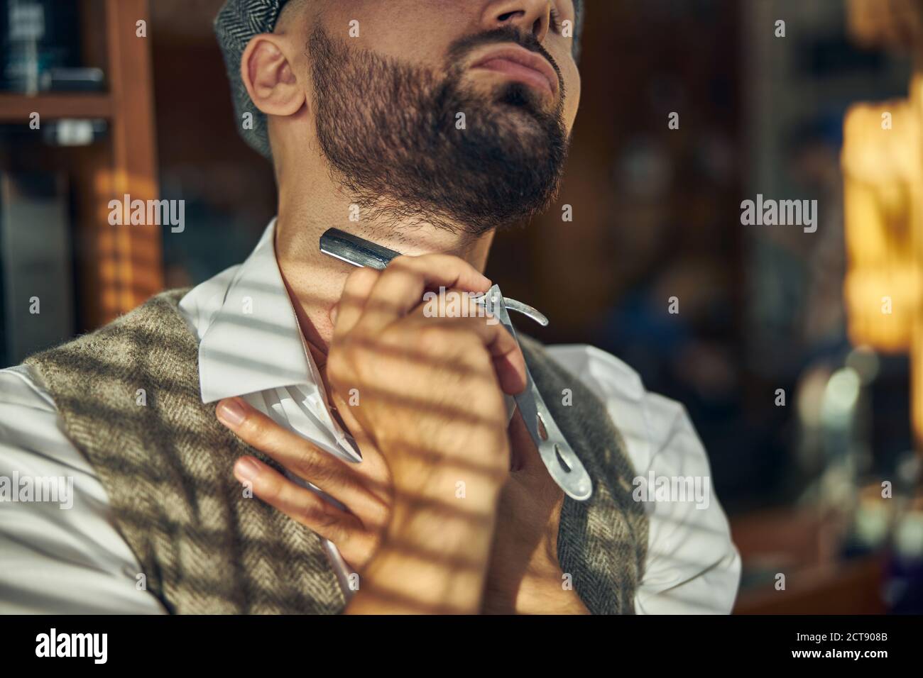 Bearded hair-stylist using a straight razor to shave his neck Stock ...