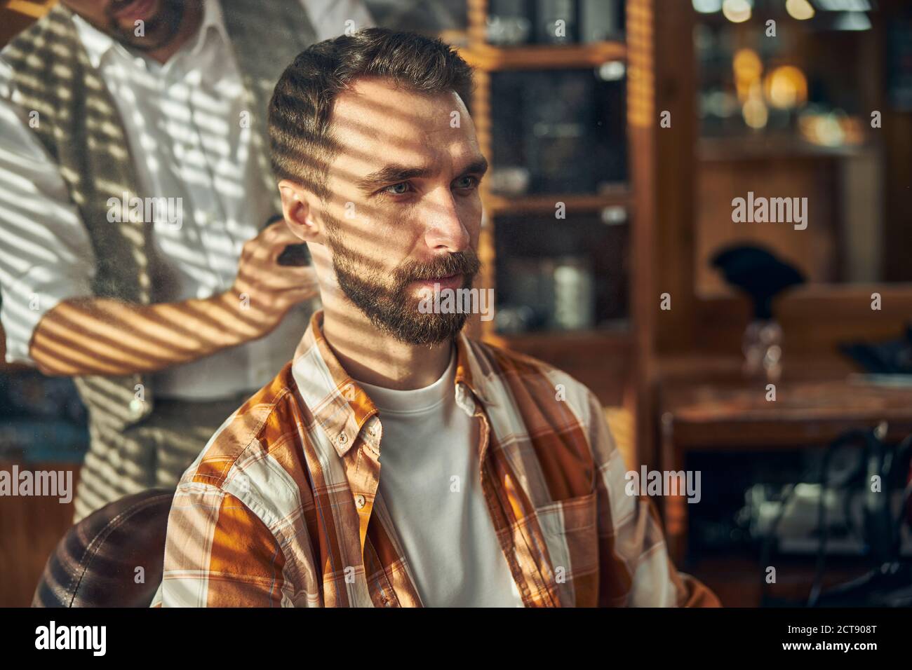 Serious barbershop client waiting for his barber to cut his hair Stock ...