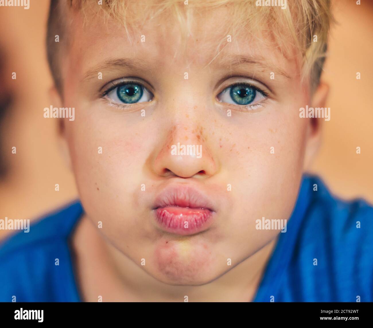 Close up portrait cute smiling blue eyed freckled blond boy pronounced ...