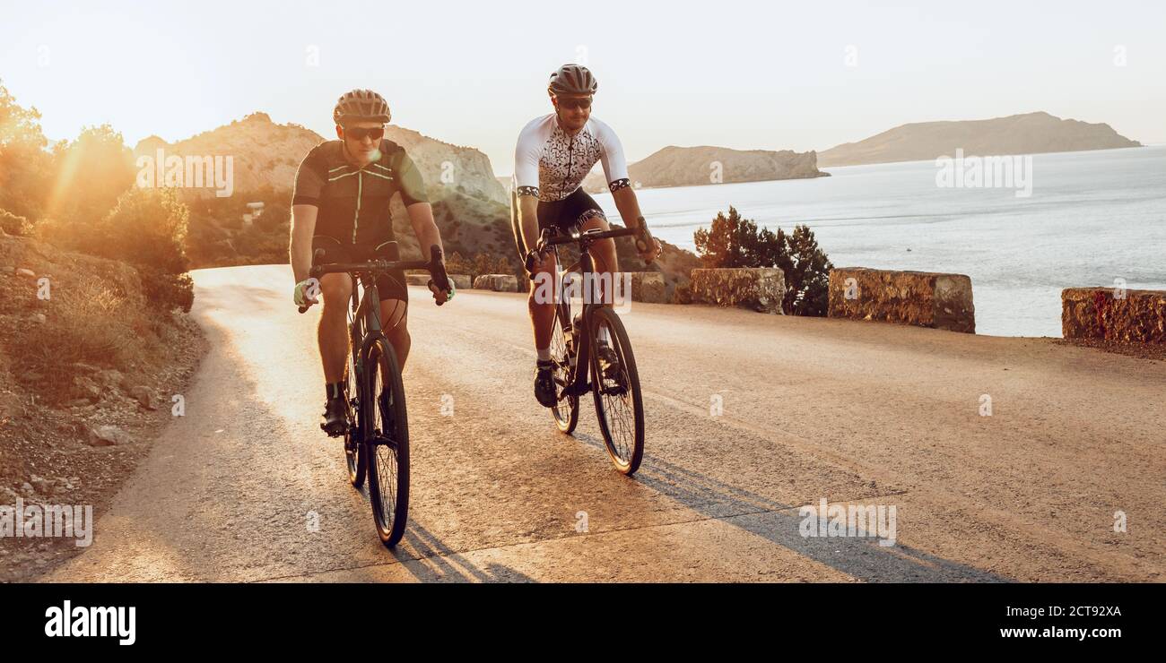 Two professional male cyclists riding their racing bicycles in the ...
