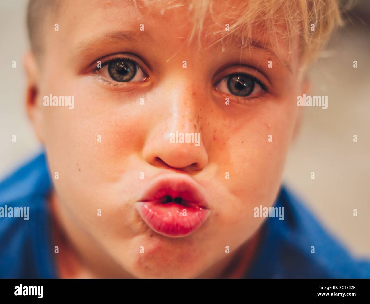 Close up portrait cute smiling blue eyed freckled blond boy pronounced ...
