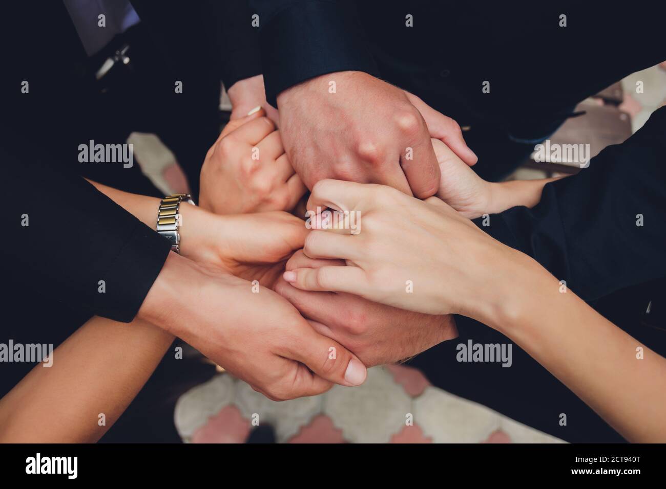 two man and three women holding hands on a table implying a polyamory ...