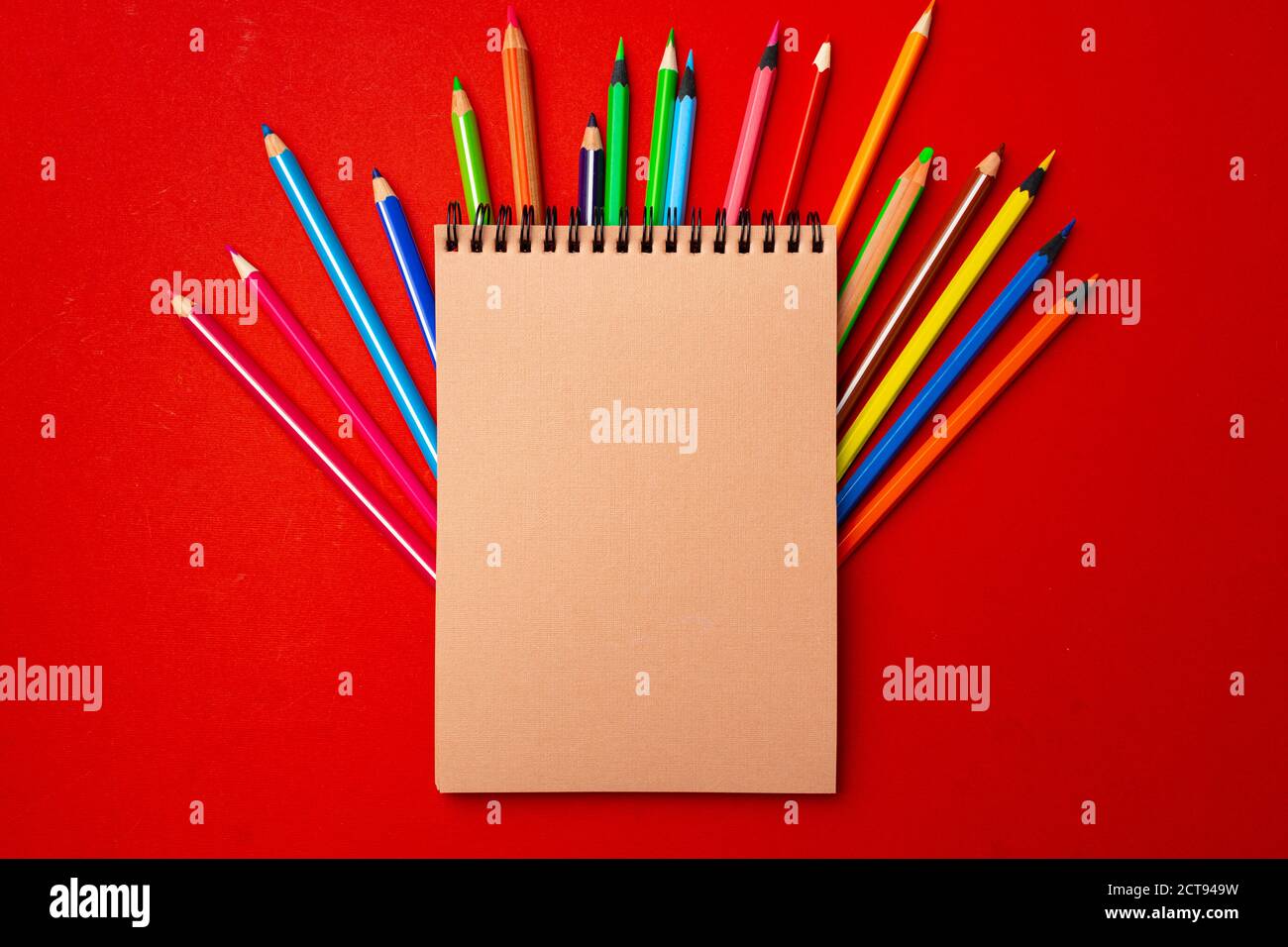 Notepad and color pencils on working space top view Stock Photo - Alamy