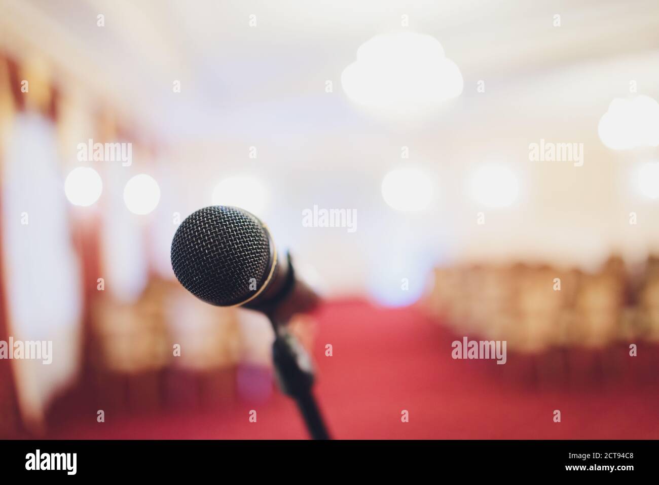 Front close up Microphone over blurred empty on the hall. Microphone on ...