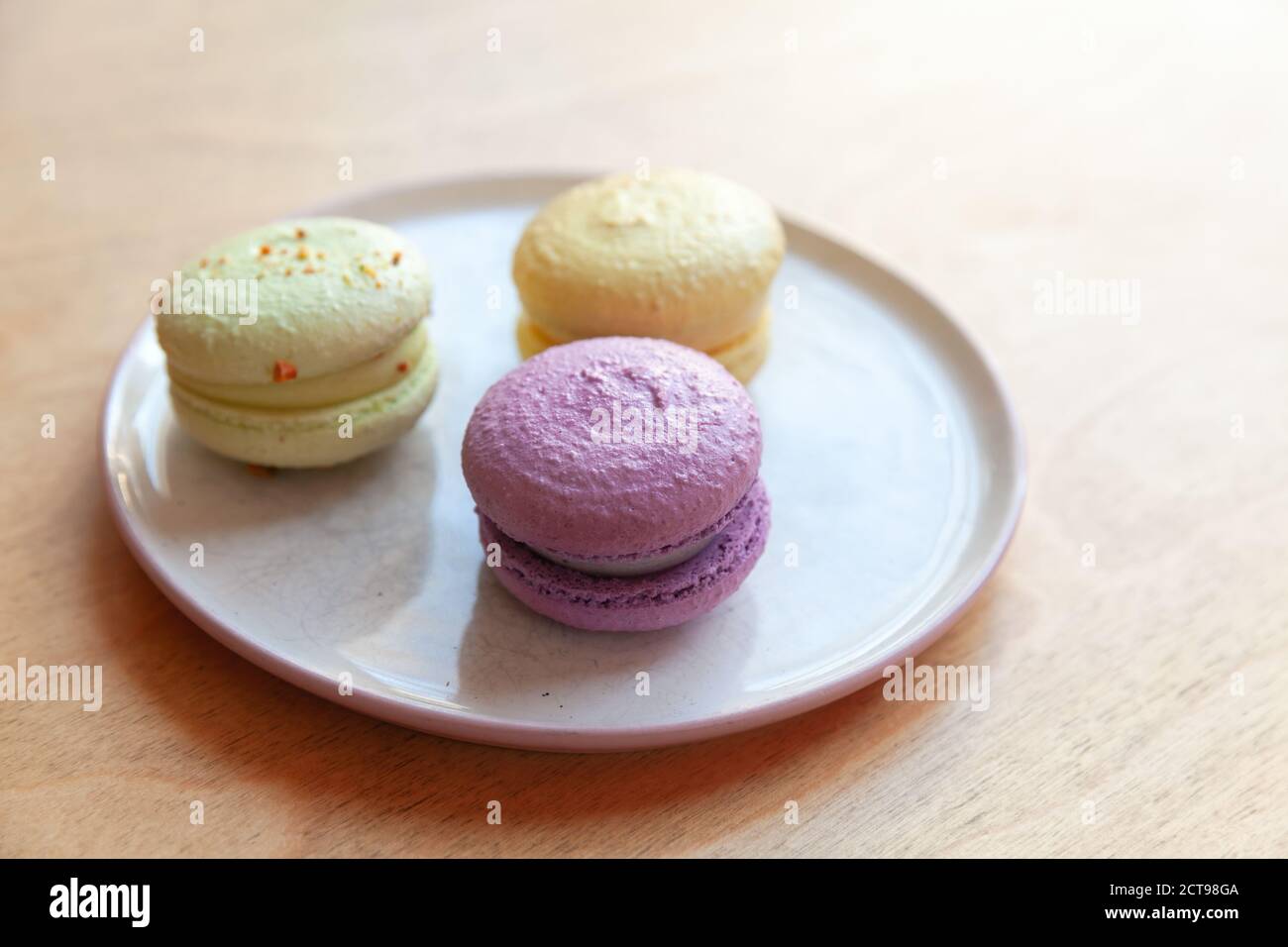 Colorful macaroons lay on a white plate, close-up photo with selective ...