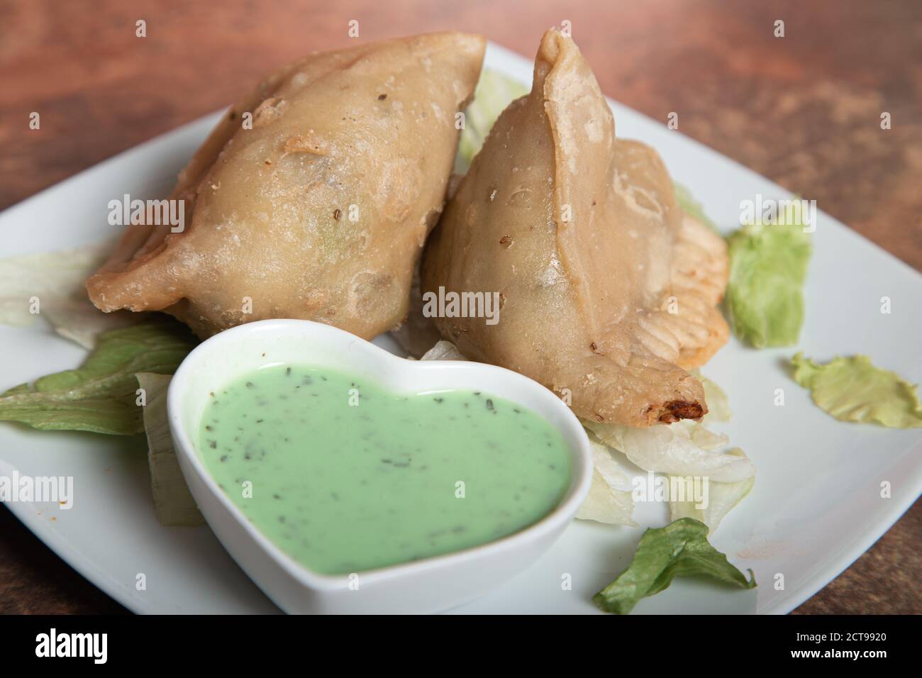 Traditional Indian or Pakistani Ramadan food, Samosa with green sauce ...
