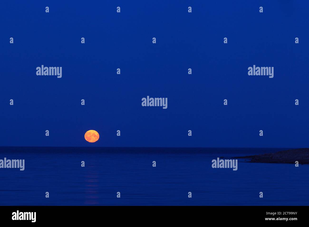 Full moon over the sea along the Baltic Sea. Blue sky and rising moon ...