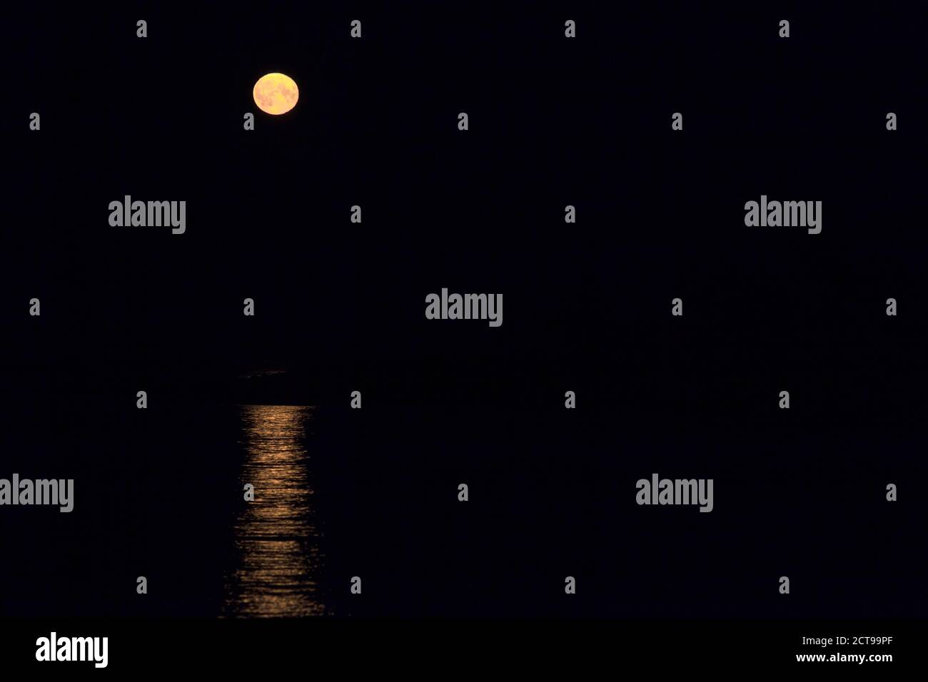 Full moon over the sea along the Baltic Sea. Blue sky and rising moon ...