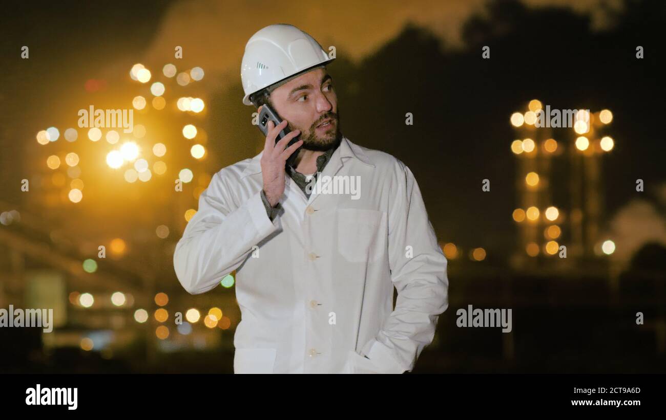 Engineer calling phone on chemical factory Stock Photo - Alamy