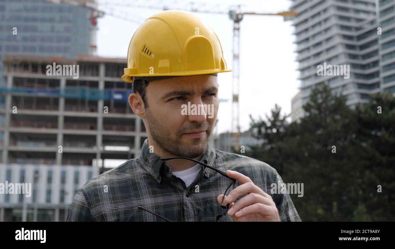 Construction worker thinking standing in front of the constructi Stock ...