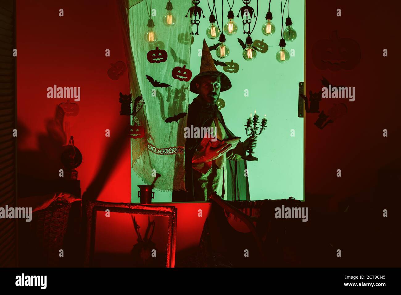 Evil witcher with red hair and a beard in a black cloak reading a book ...