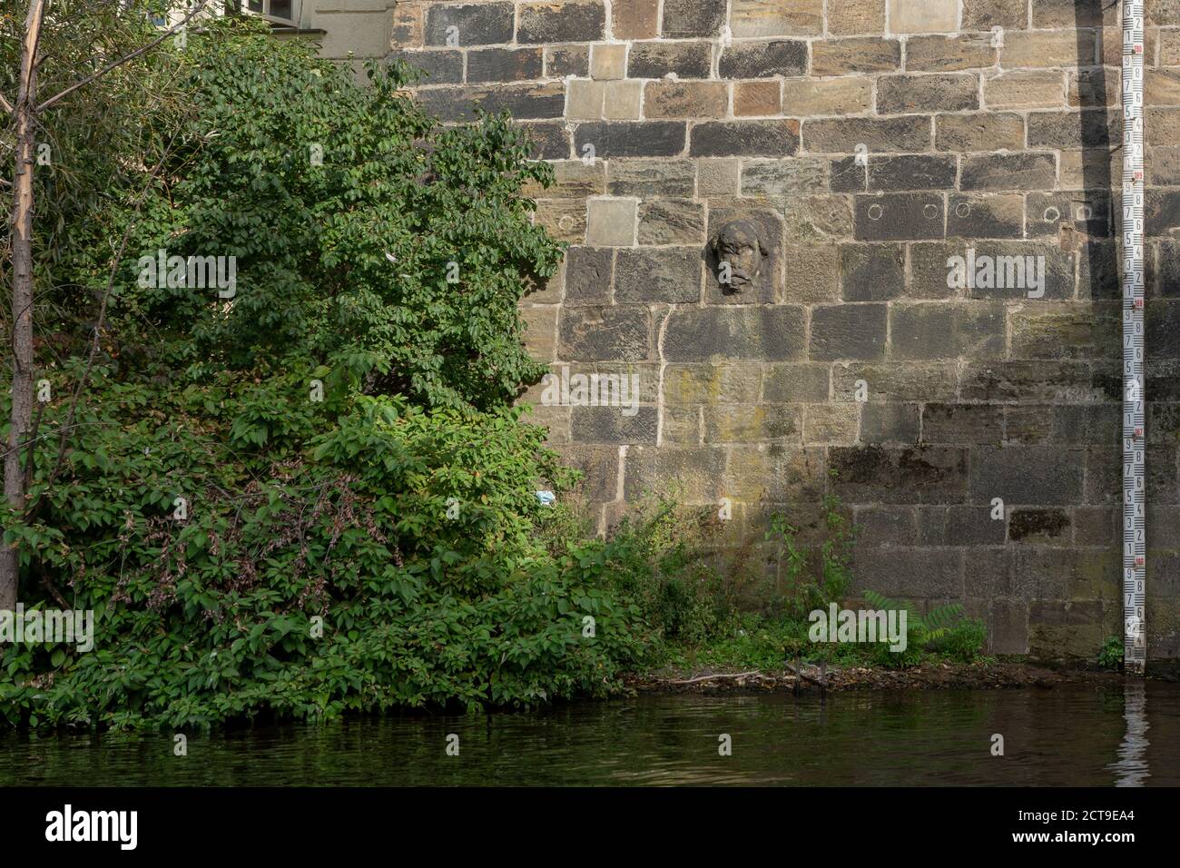 Stone wall with face of "Bradáč" (Bearded One) a medieval flooding ...