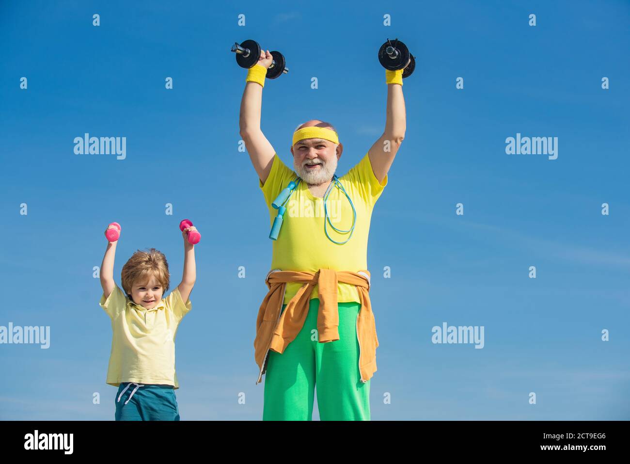 Sportsman grandfather and healthy kid with dumbbell exercise. Children ...