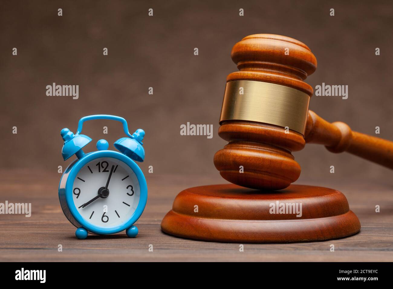 Alarm clock and hammer judge gavel on brown background Stock Photo - Alamy