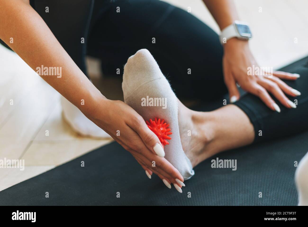 The trainer massages female feet with spiked ball, prevention of flat ...