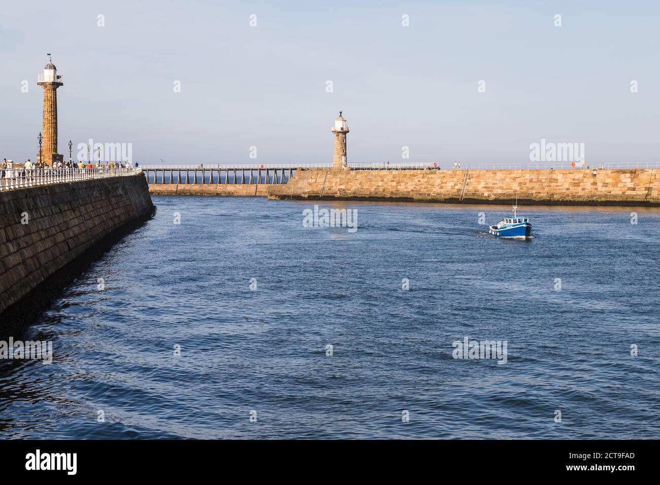 Fishing boat enters Whitby harbour between the two long piers Stock ...