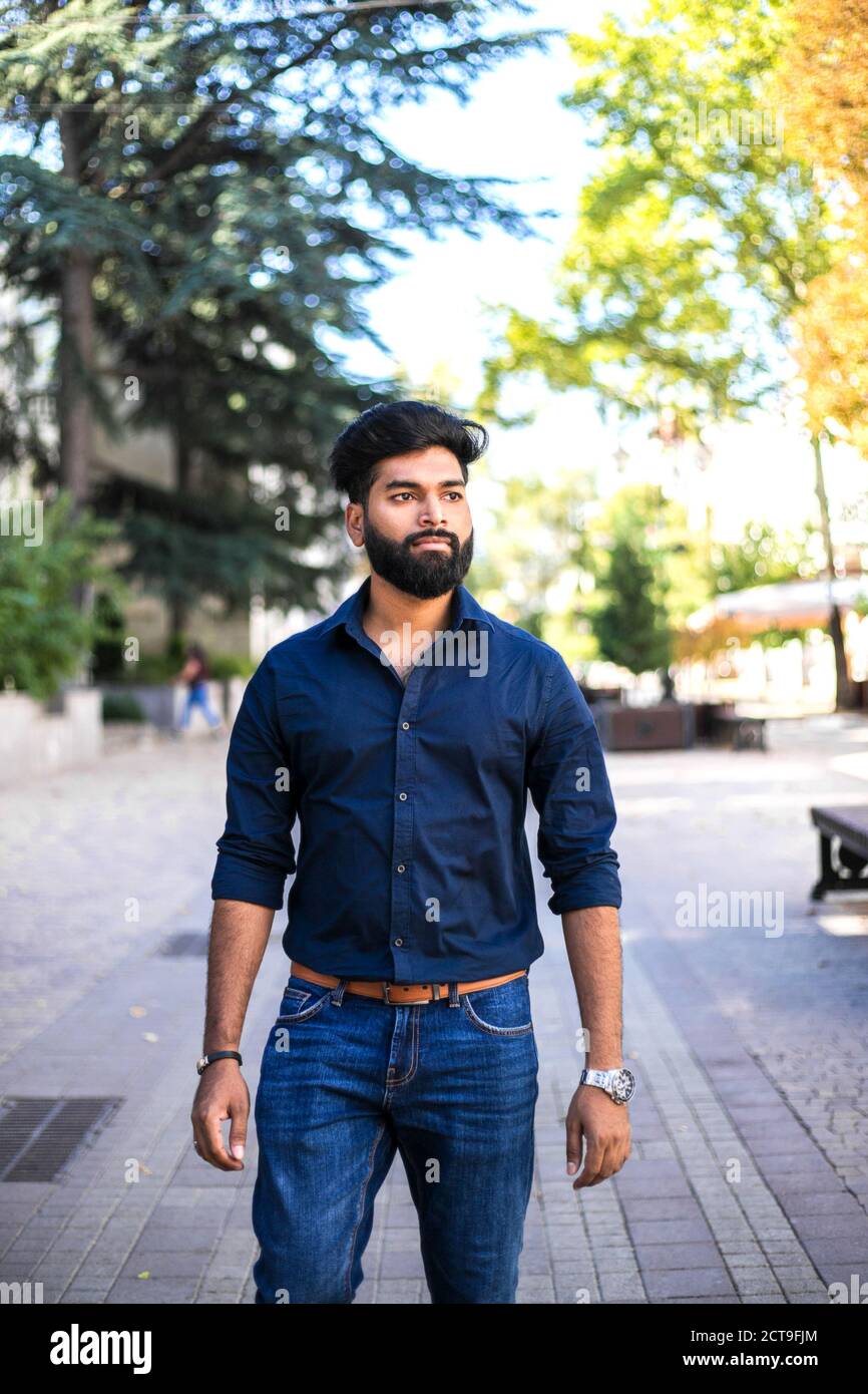 Young Indian man walking in the street Stock Photo - Alamy
