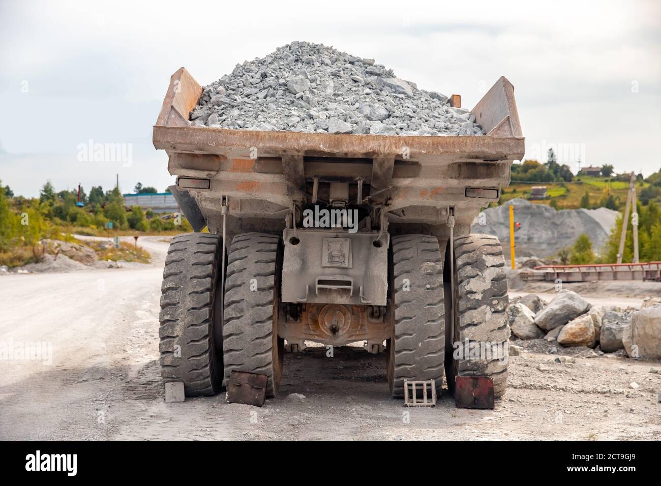 Stone open pit. Heavy duty truck filled with gravel for processing ...