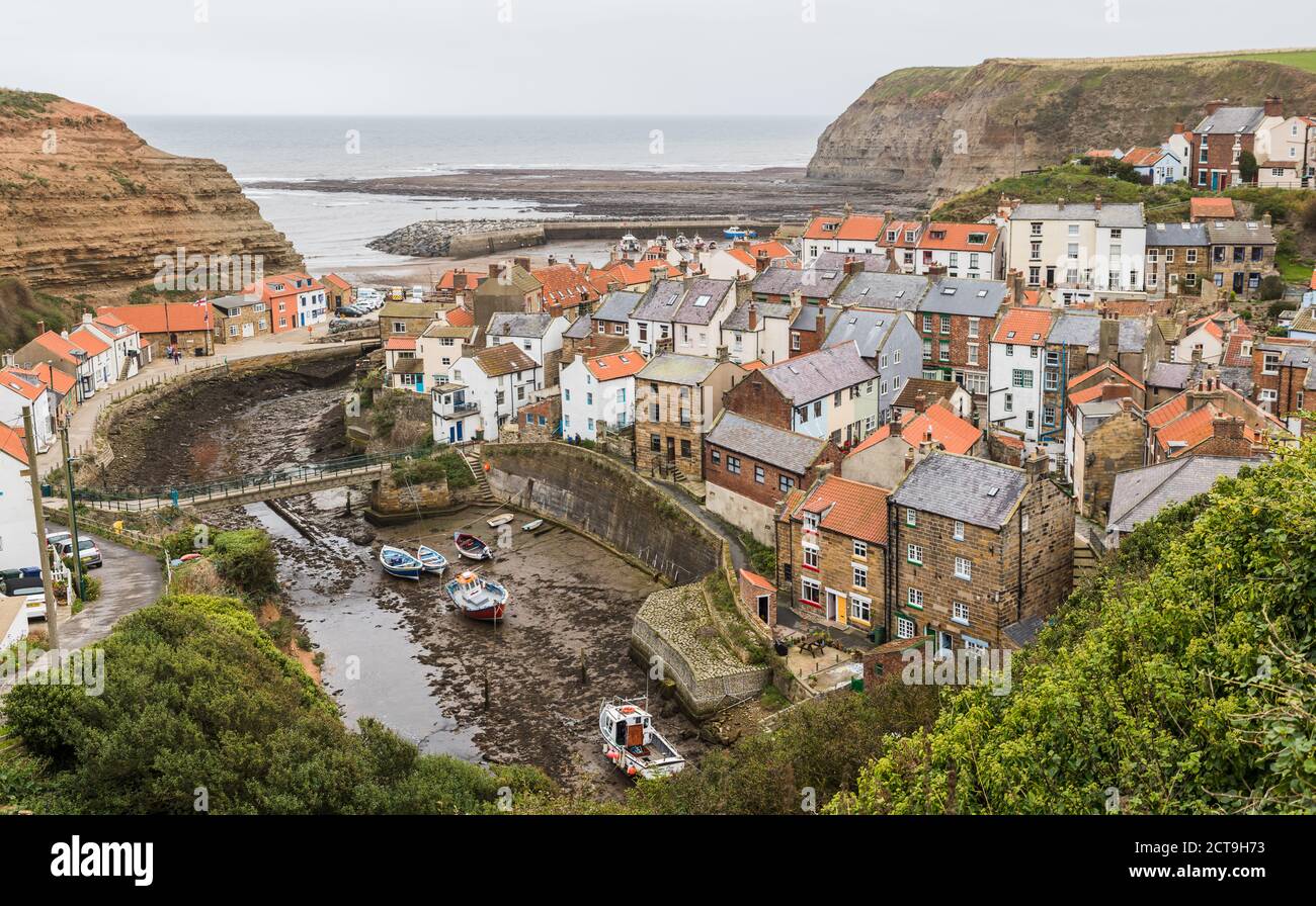 Houses clustered together in Staithes as the Roxby Beck winds through ...