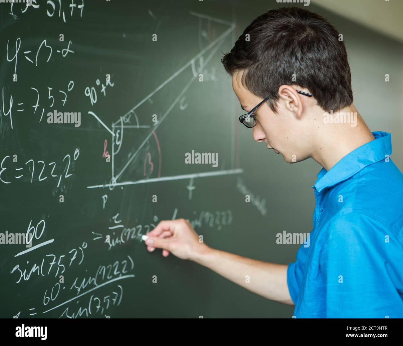 Austria, Student calculating at blackboard Stock Photo - Alamy