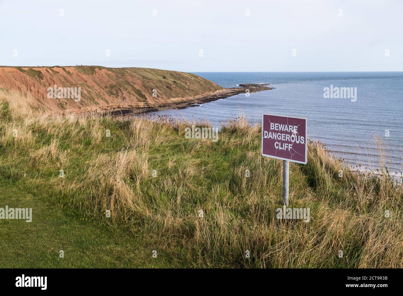 Warning sign seen on the approach to the rugged cliffs of Filey Brigg ...