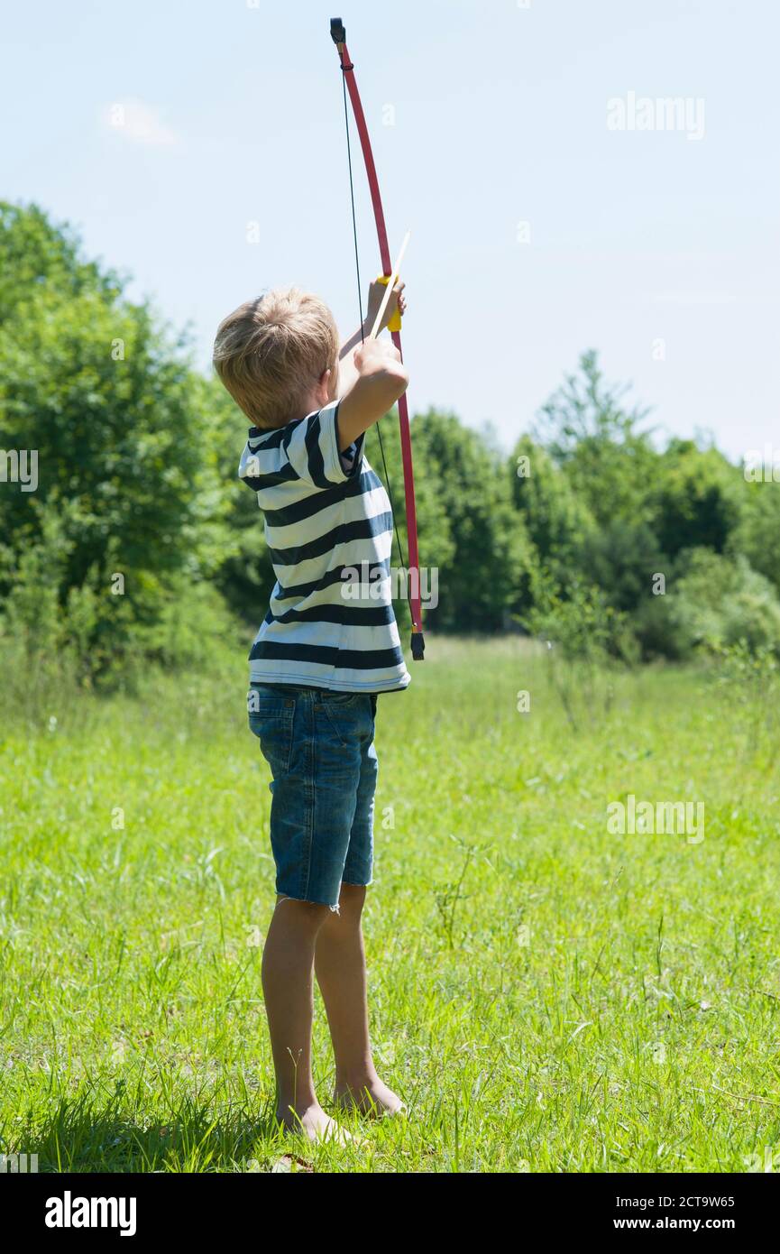 Germany, Bavaria, boy playing with bow and arrow Stock Photo - Alamy
