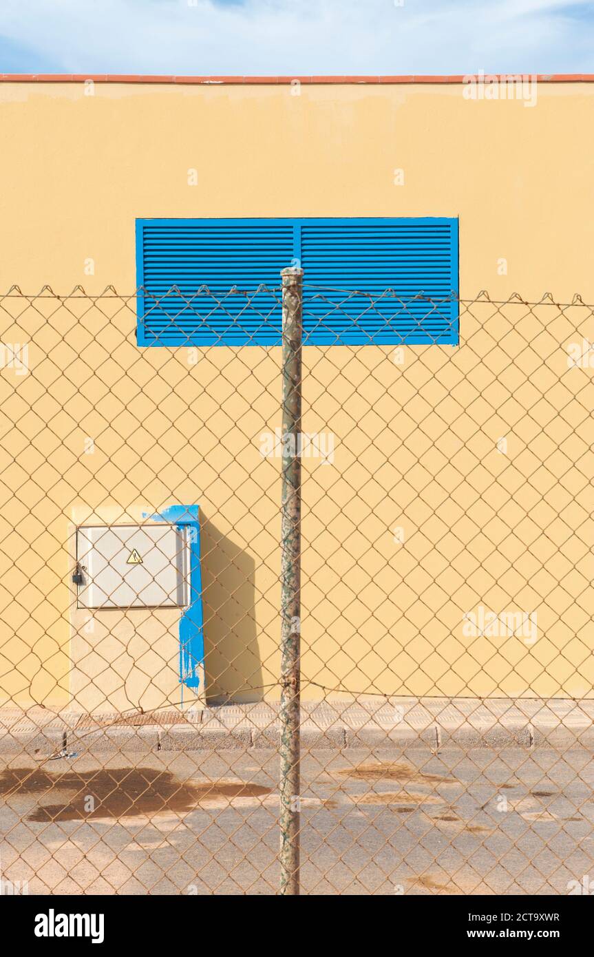 Spain, Fuerteventura, fence in front of yellow facade Stock Photo - Alamy