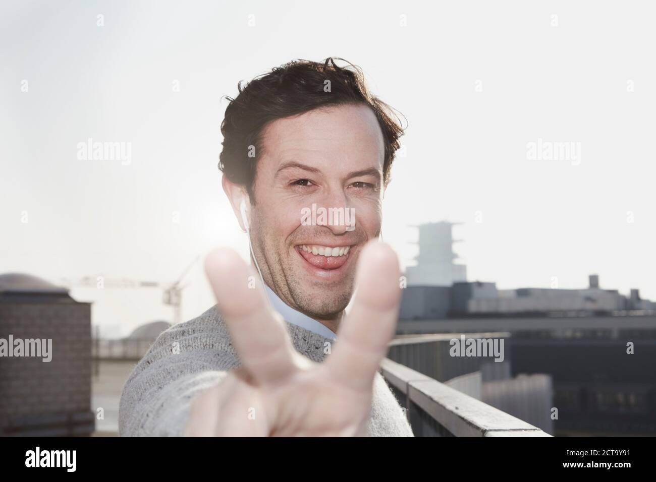 Smiling man showing victory sign hi-res stock photography and images ...