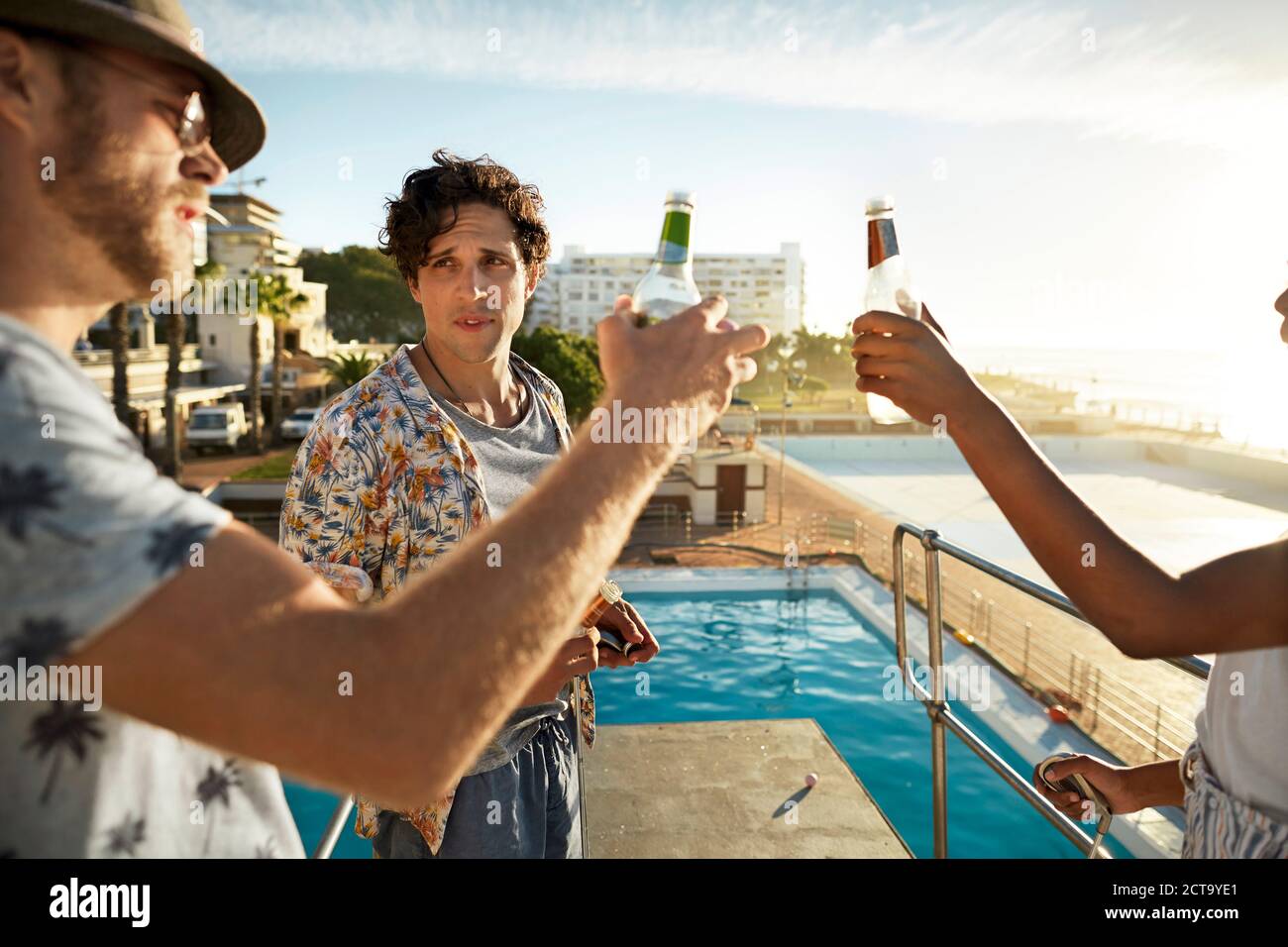 Friends drinking beer on highboard of a swimming pool Stock Photo - Alamy