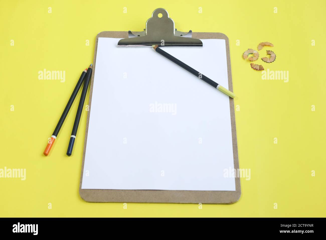 Shot of a drawing board with pencils on a yellow background Stock Photo ...