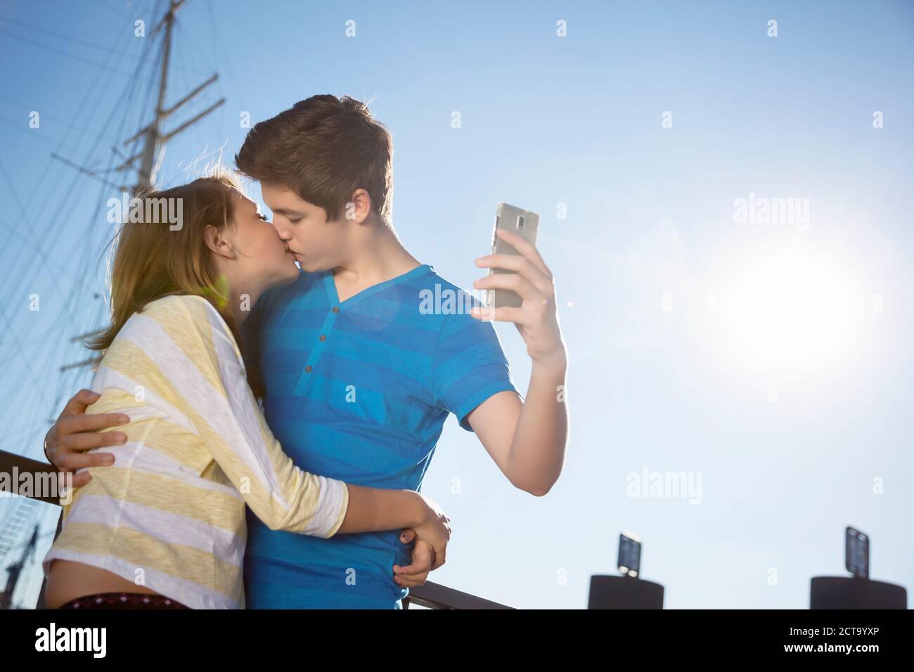 Teenage couple kissing while photographing themself Stock Photo - Alamy