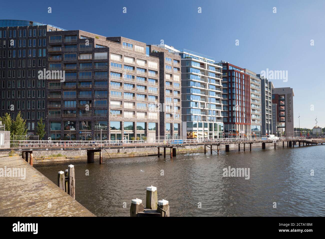 Netherlands, Amsterdam, Office buildings and library at town canal ...