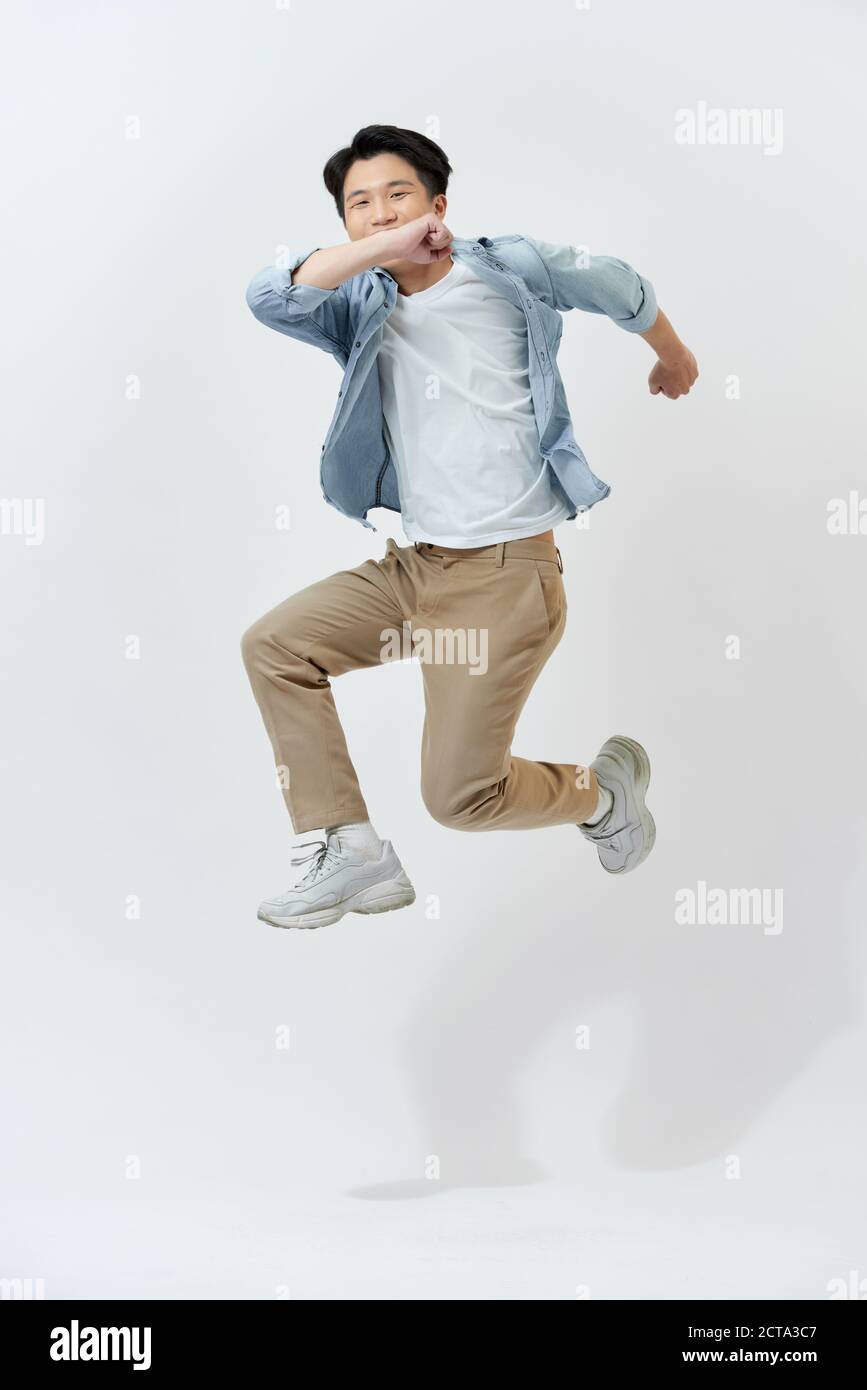 Young Asian man jumping in the air on white background Stock Photo - Alamy
