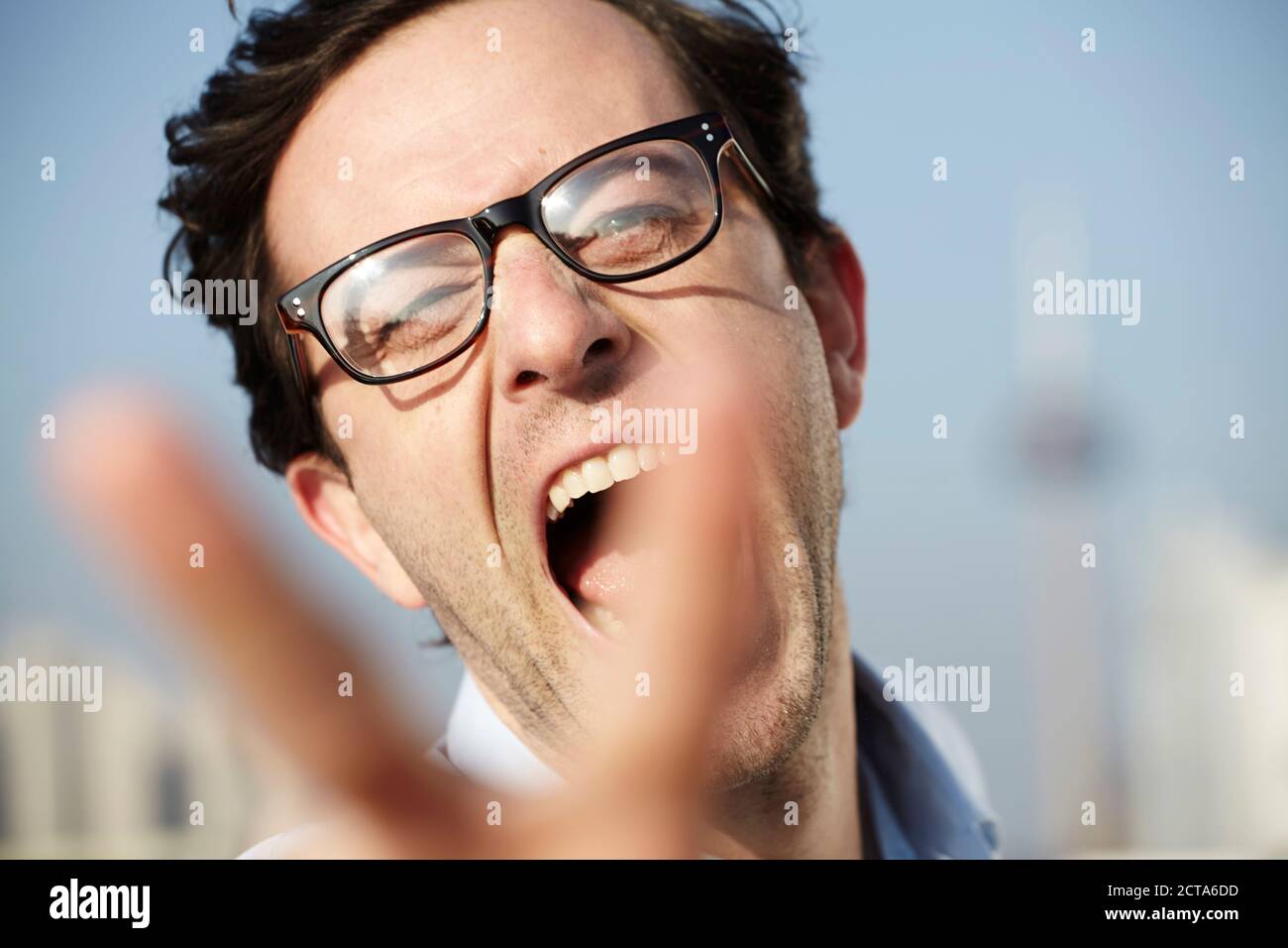 Portrait of screaming man showing victory sign Stock Photo - Alamy