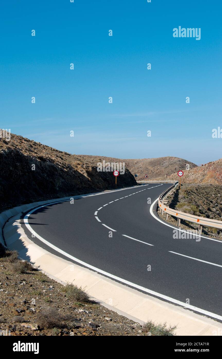 Spain, Fuerteventura, Pajara, curve of the road at mountainscape Stock ...