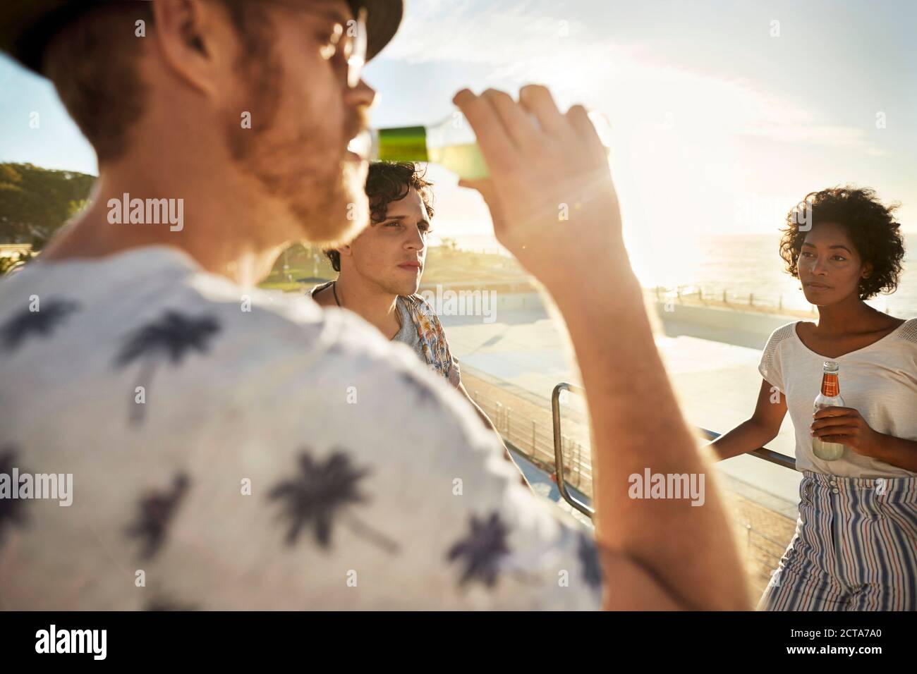 Friends drinking beer on highboard of a swimming pool Stock Photo - Alamy