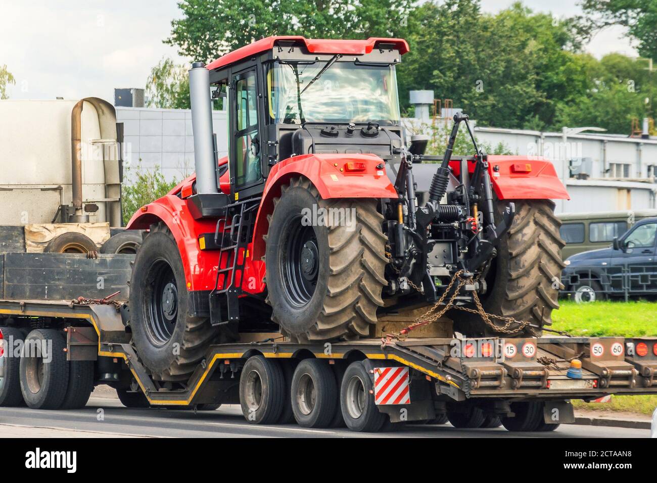 Powerful red tractor on a platform trailer road transportation Stock ...