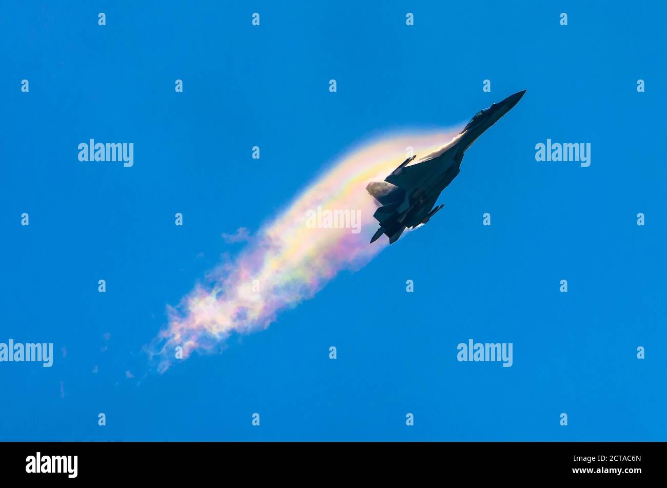 Battle fighter jet aircraft flying dives breaking clouds on a blue sky ...
