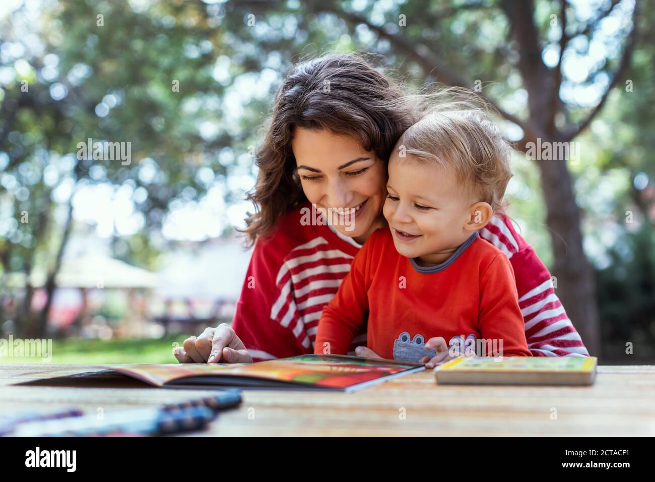 Mother and Son Reading Books at the Garden, with Crayons on the Picnic ...
