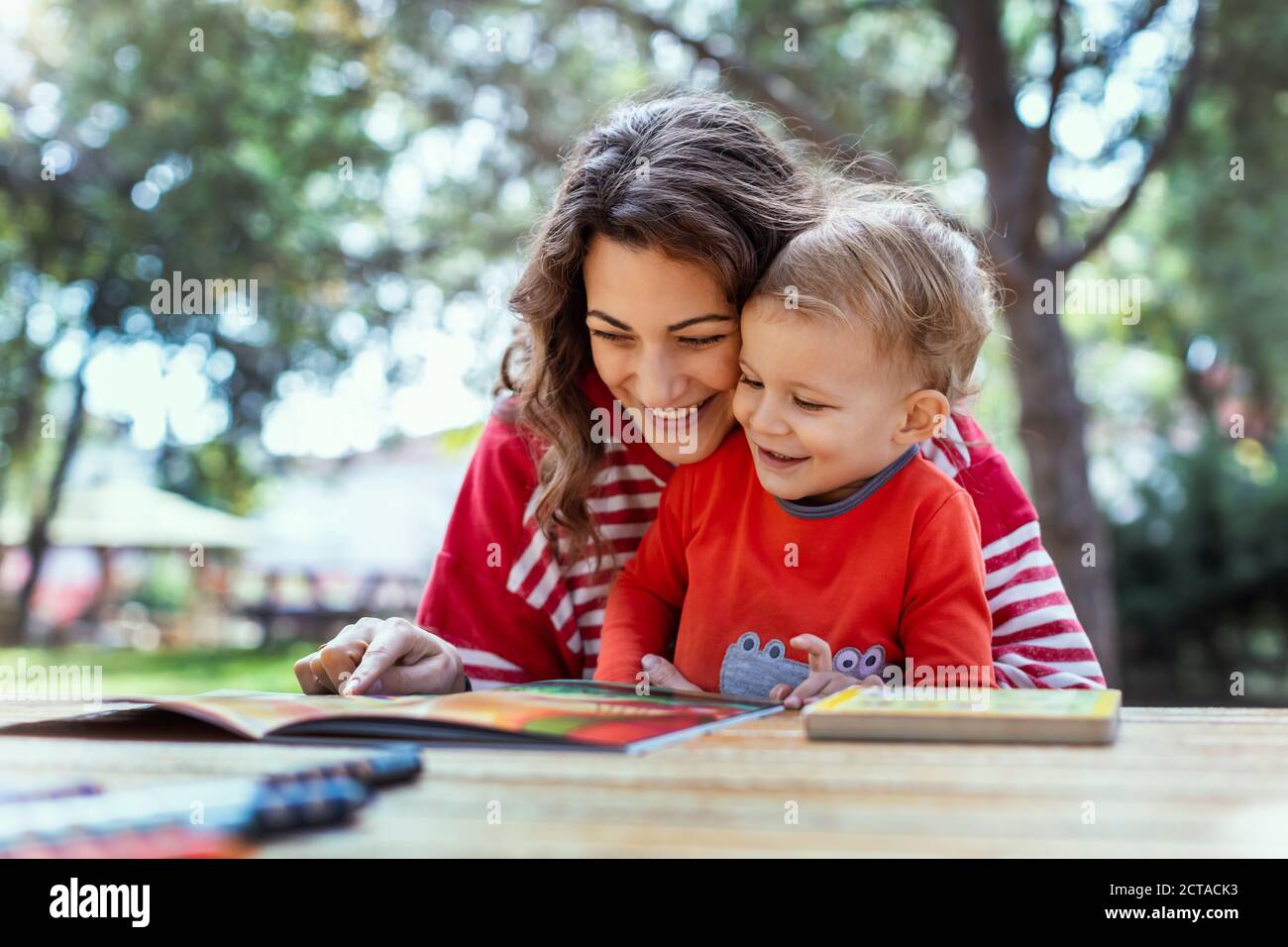 Mother and Son Reading Books at the Garden, with Crayons on the Picnic ...