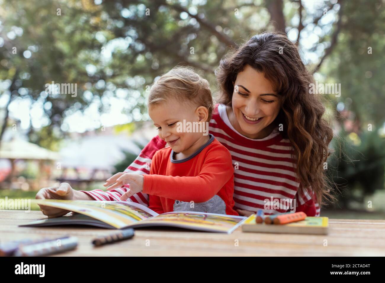 Mother and Son Reading Books at the Garden, with Crayons on the Picnic ...