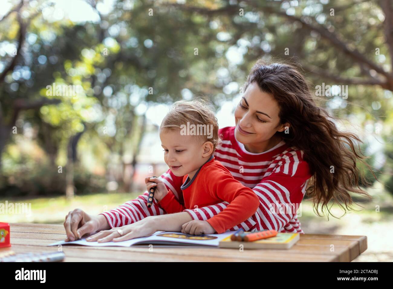 Mother and Son Reading Books at the Garden, with Crayons on the Picnic ...